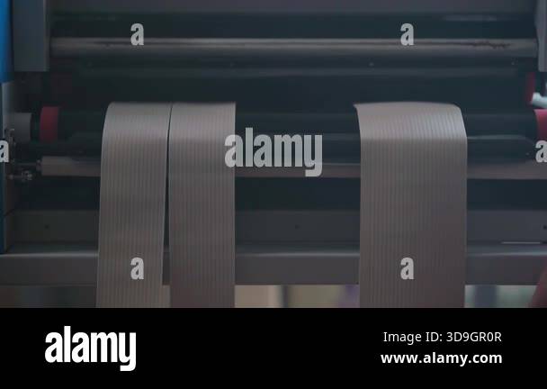 Elastic corset bands pass through machine rollers in a smooth ...