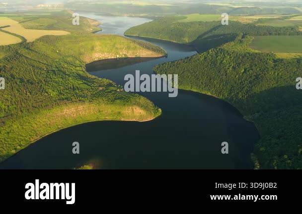 Panoramic view of the meandering river flowing through the green hills ...