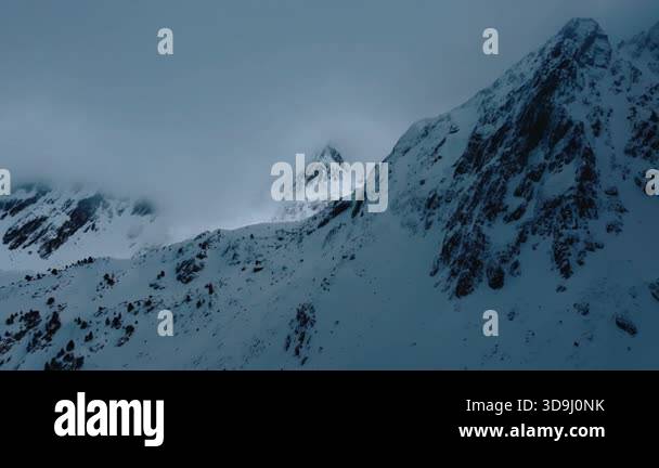 Cold winter scenery, drone flies over mountains focused on snowed peak ...