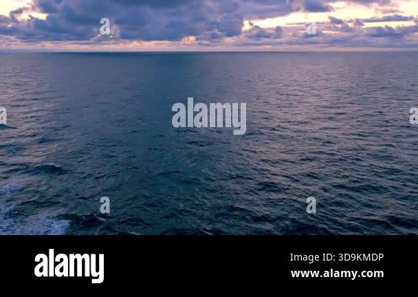 Cinematic ocean sunrise captured from a moving ship with dramatic ...