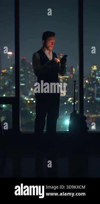 white traveler standing by window at night overlooking city lights ...