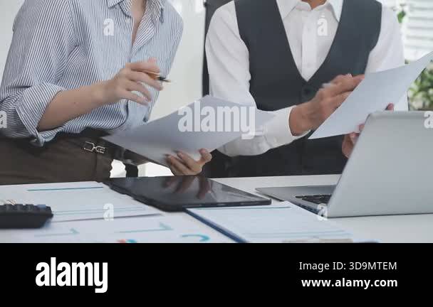 Two financial accountants analysing business spreadsheets on laptop ...