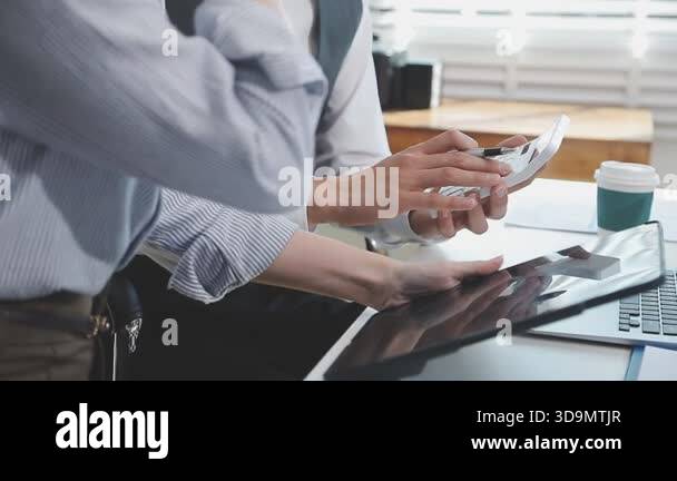 Two financial accountants analysing business spreadsheets on laptop ...