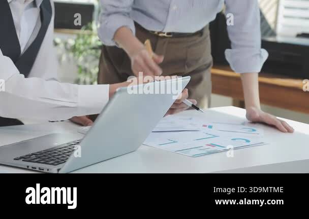 Two financial accountants analysing business spreadsheets on laptop ...