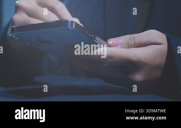 A man's hands are busy typing on a laptop keyboard during the nighttime ...