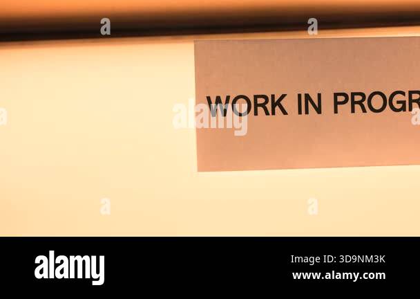 Work in progress sign illuminated by warm cozy lamp light. High quality ...