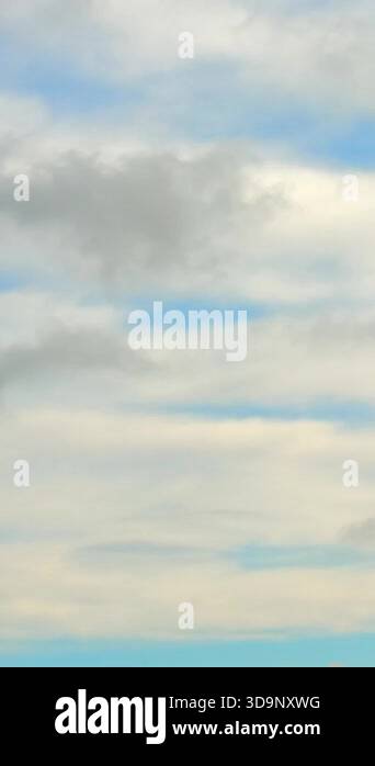 Clouds dominate the sky with varying shades of grey and soft blue. The ...