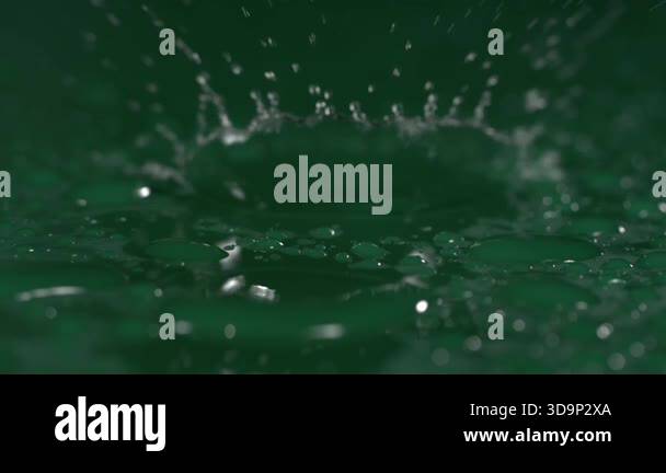 Calm water droplets rest on a smooth dark surface, creating a soothing ...