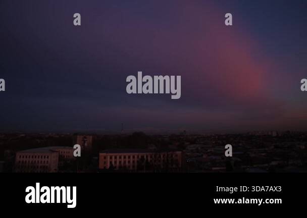 Beautiful pink sunset over the city. A television tower can be seen in ...