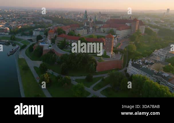 Drone flies, backwards away from Wawel Castle revealing Vistula River ...