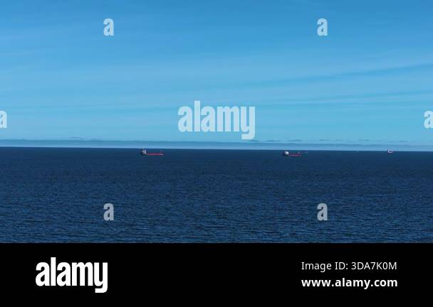 Seascape with cargo ships anchored on calm ocean surface. Maritime view ...