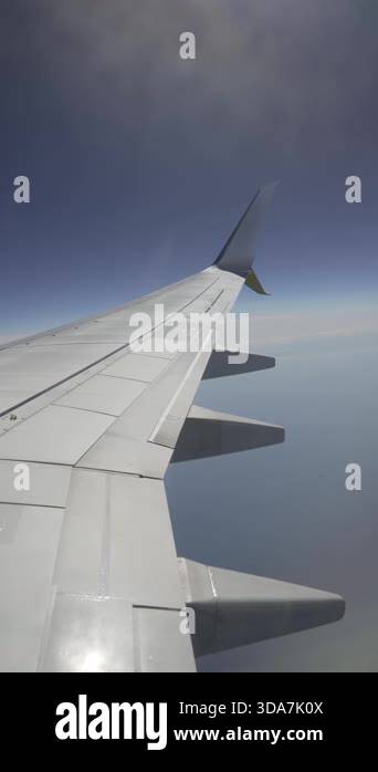 Jet flying over calm blue sea under clear sky. Aircraft cruising above ...