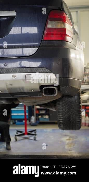 workshop scene with tools and lifted vehicle, automotive service bay ...