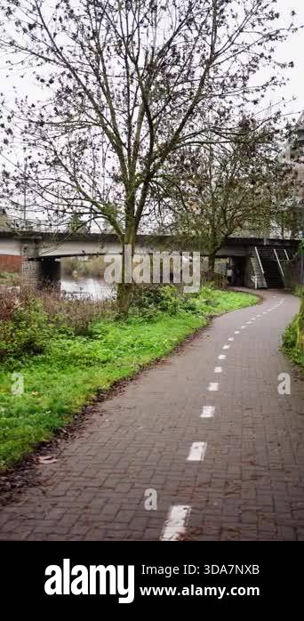 gentle curved pathway crossing serene river, scenic paved track winding ...