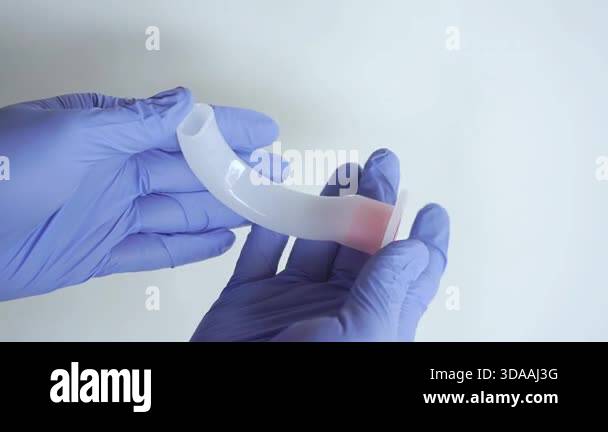 Medical worker wearing medical gloves holding an OPA (Oropharyngeal ...