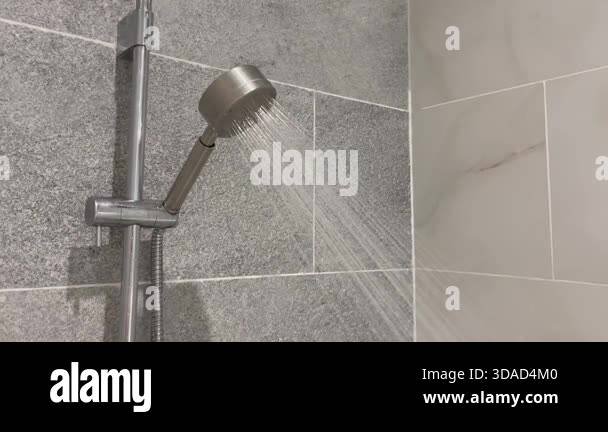 Water flowing from modern shower in the bathroom, focus on water sprays ...