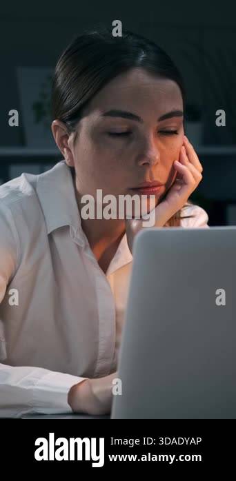 Tired young businesswoman stretching arms, waking up and continuing to ...