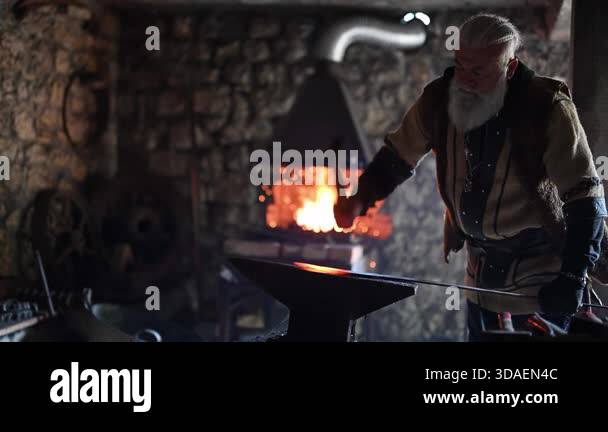 A Viking blacksmith with a white beard and braided hair works intently ...