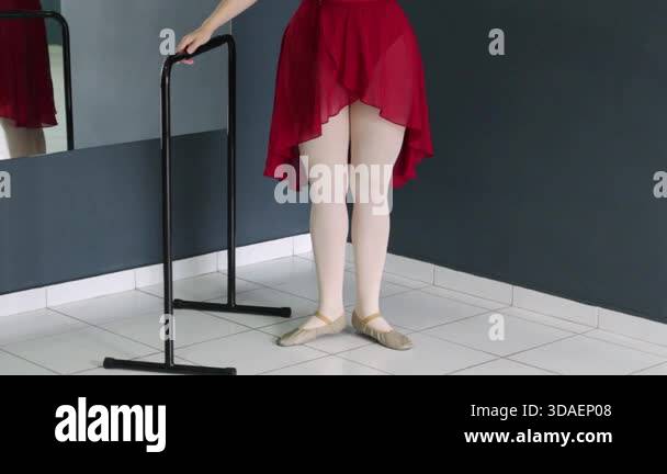 Ballerina performing elev, pli and grand pli beside the barre. Horizontal video perfect for ...