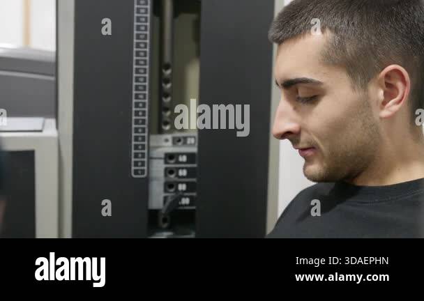 Close-up of a young man working out. His focused face is seen in ...