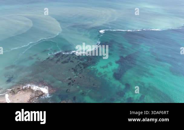 Aerial drone footage of turquoise ocean water with gentle waves moving ...