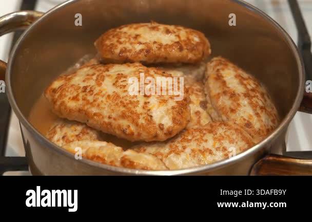 Meat cutlets are stewed in saucepan. Meat patties are cooked in metal ...