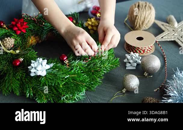 Close-up of small hands holding a decorated Christmas wreath during a ...
