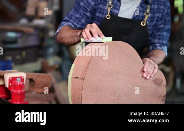 Luthier making top of guitar using traditional tools in workroom with ...