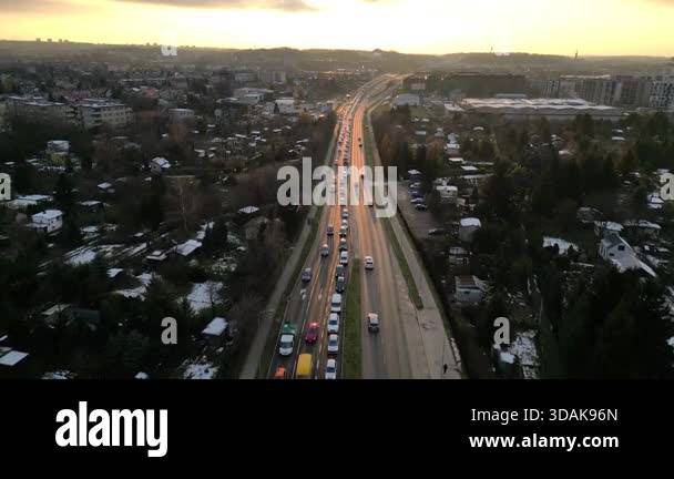 Aerial view transitions to a road with moving cars at sunset, capturing ...