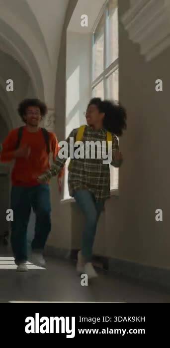 Happy multiracial students running laughing university corridor rushing ...