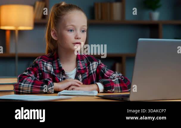 Serious Caucasian kid child girl talking video call with laptop in ...