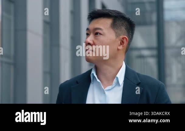 Portrait in city Asian business man looking away pensive smiling toothy ...