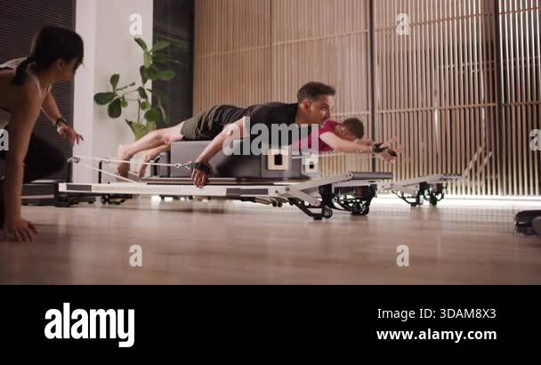 Participants perform various strength exercises in a stylish fitness ...