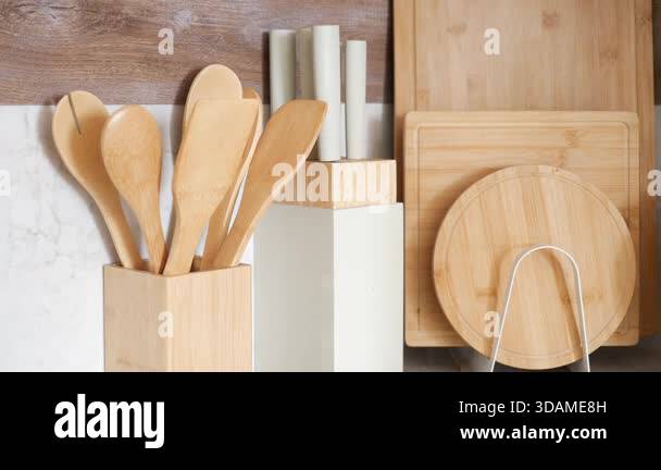 Various wooden kitchen tools and cutting boards are arranged neatly ...
