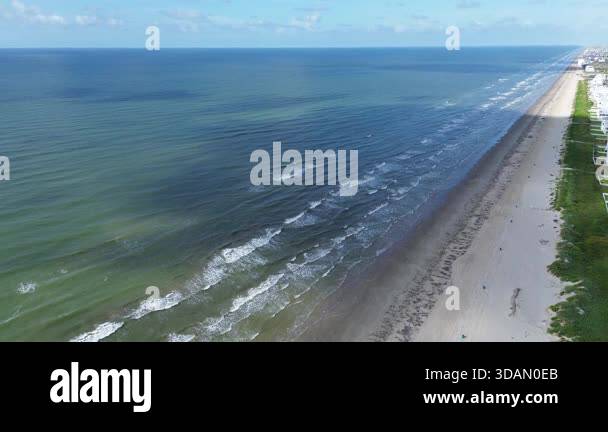 Long sandy shoreline at Sunny Beach by grassy vegetation, residential ...