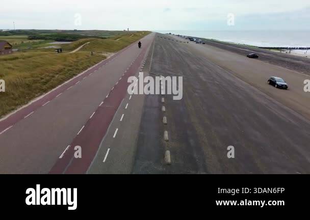 Elevated view of coastal road with bike lane, car lanes, grassy dunes ...
