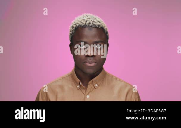 Portrait of Young Black Man Looking at Camera Smiling in Colour Studio ...