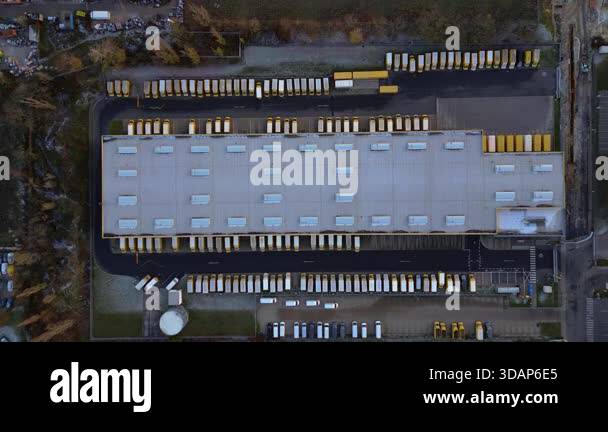Large warehouse facility with numerous trucks parked at loading docks ...