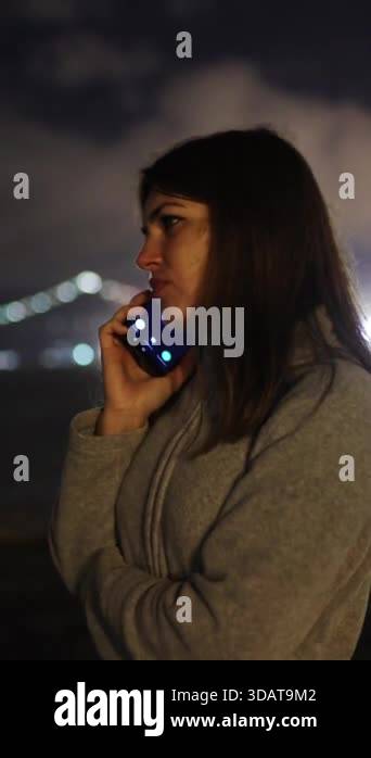Sad woman crying and talking on her smartphone during a difficult night ...