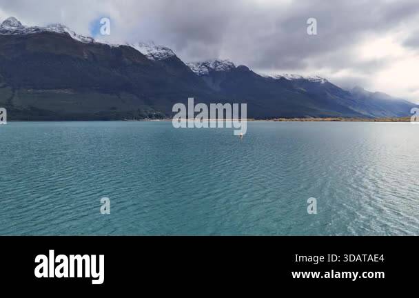 Tranquil lake with mountain backdrop under cloudy skies in Glenorchy ...