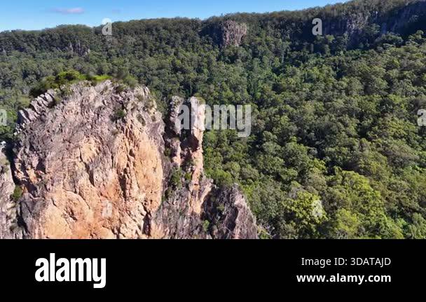 Drone footage captures Nimbin Rocks surrounded by dense forest under ...