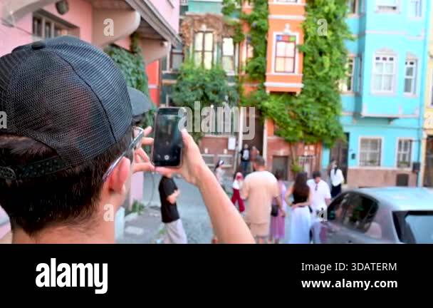 Istanbul, Turkey, August 1, 2025. A young man takes photos with his ...