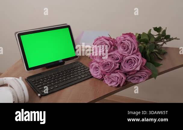 Slow camera move toward office desk with tablet, keyboard, and flower ...