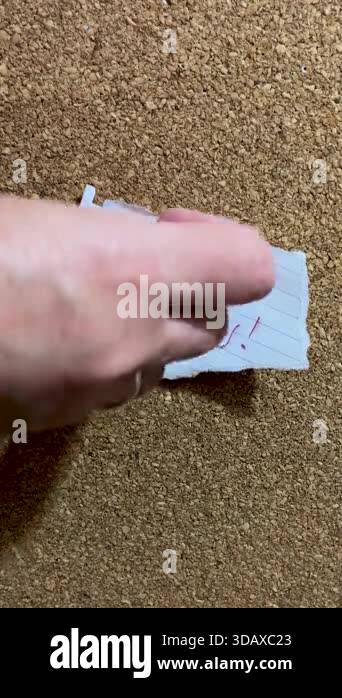 Close-up of a hand pinning a handwritten note with the words 'Be happy ...
