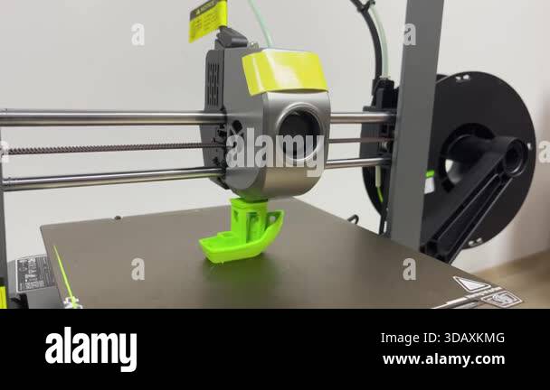 The 3D printer is printing a bright neon green Benchy boat. Ideal for ...