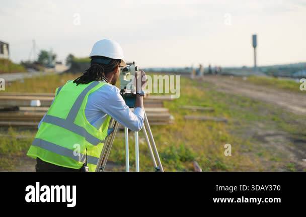 African american surveyor wearing a hard hat and safety vest working ...