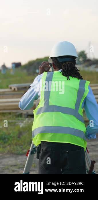 African american land surveyor wearing a hard hat and safety vest ...