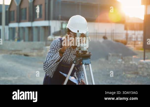 Professional land surveyor using a theodolite and tablet for geodetic ...
