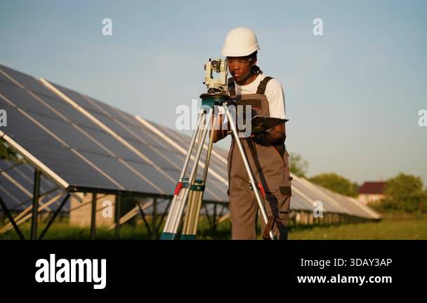 African american surveyor using a theodolite for land measurement ...