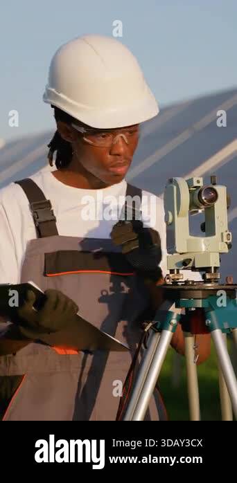Professional surveyor working with a theodolite on a solar farm ...